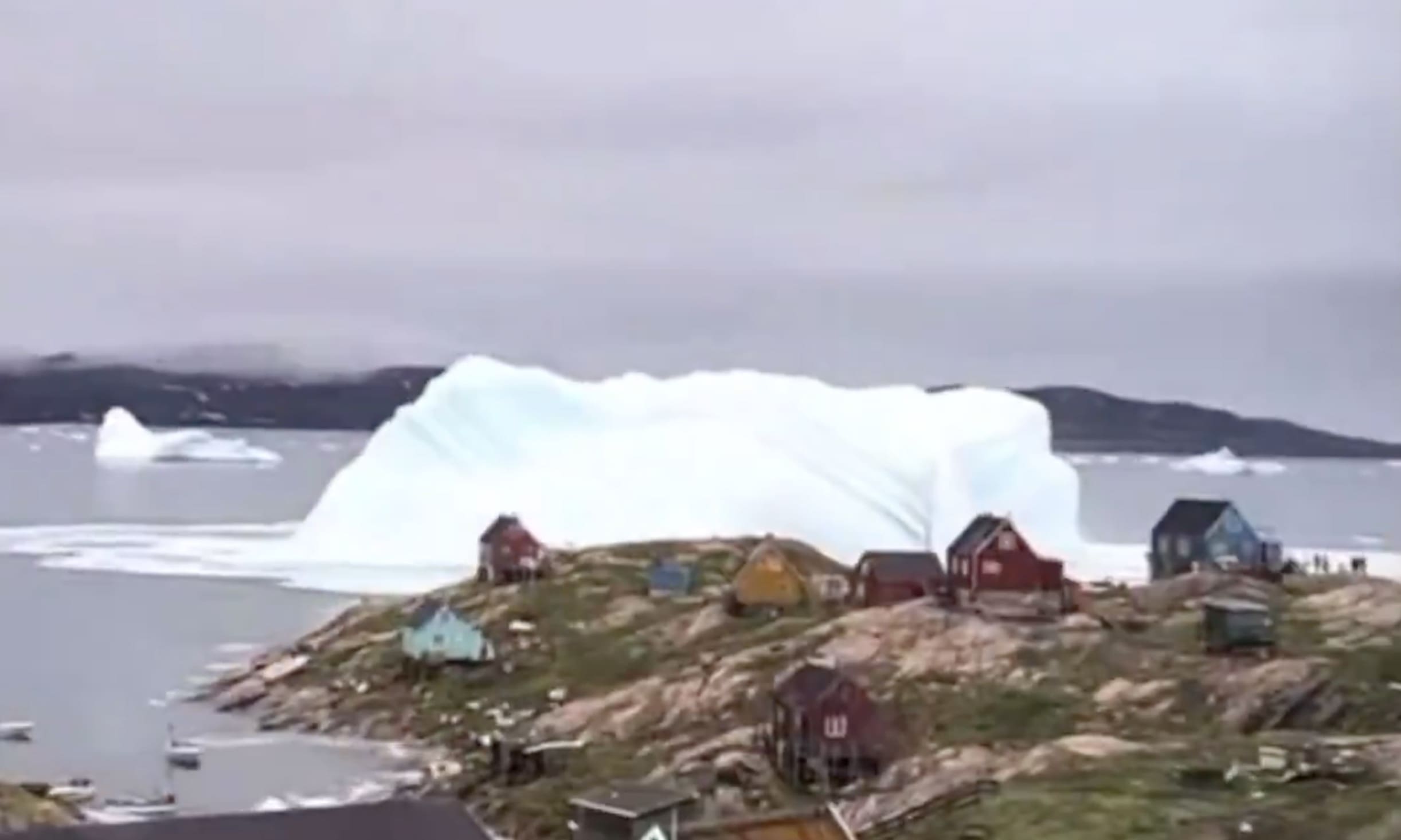 Massive Iceberg Barrel Rolls In Front of Remote Greenland Village ...